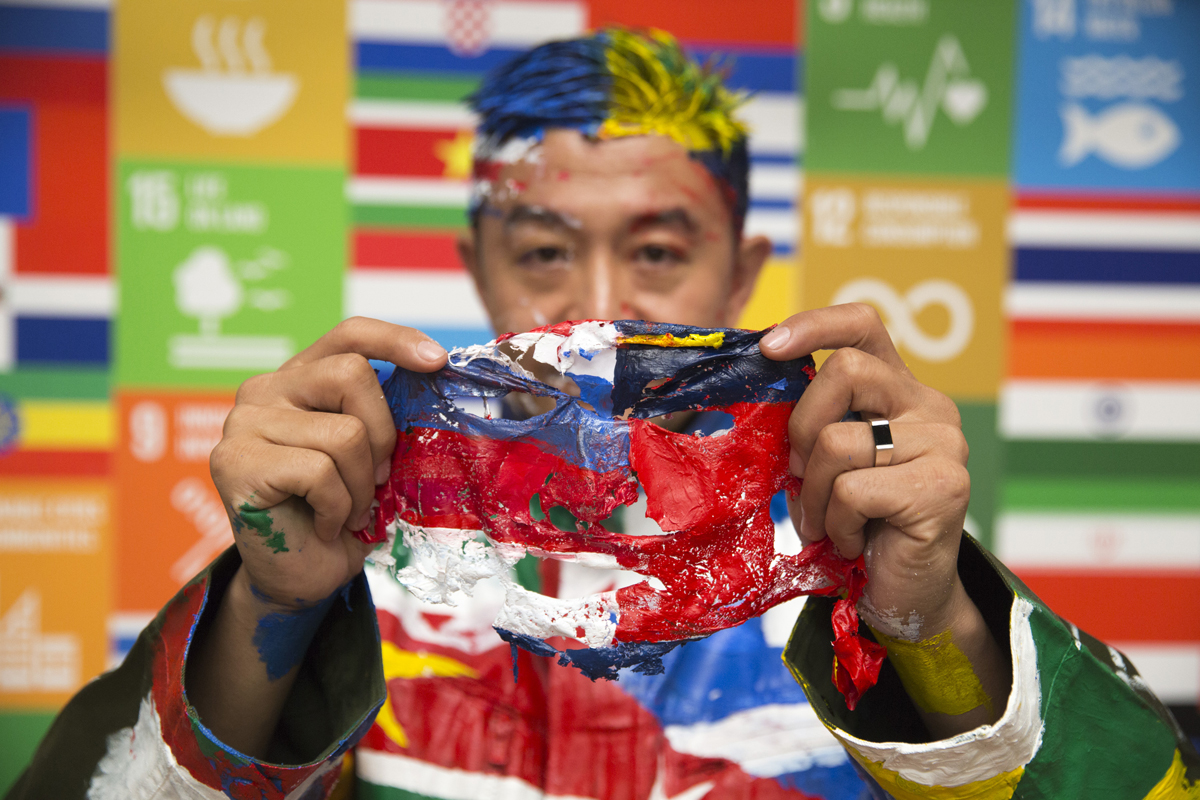 Liu Bolin disappears into a collage of flags, for UN Global Goals | TED ...